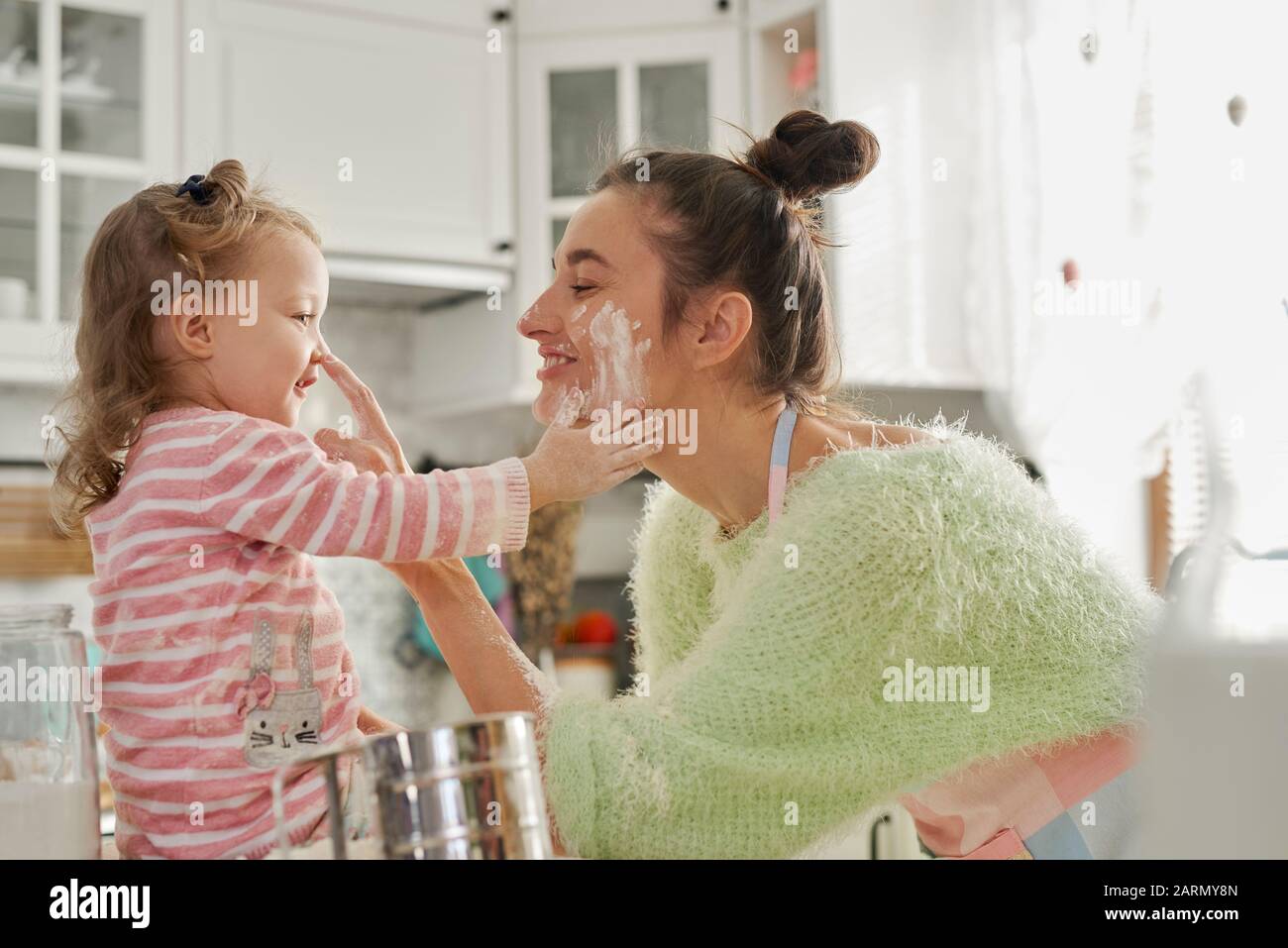 Mother and daughter having fun with flour in the kitchen Stock Photo ...