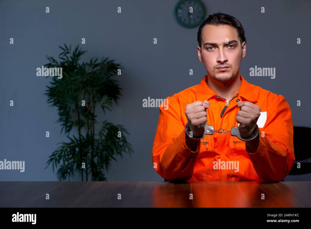 The young convict man sitting in dark room Stock Photo - Alamy