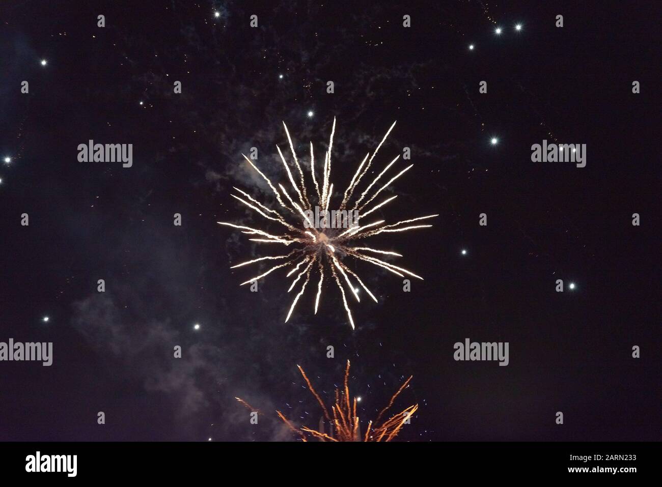 A flash of plain white and orange fireworks. In the night sky Stock ...