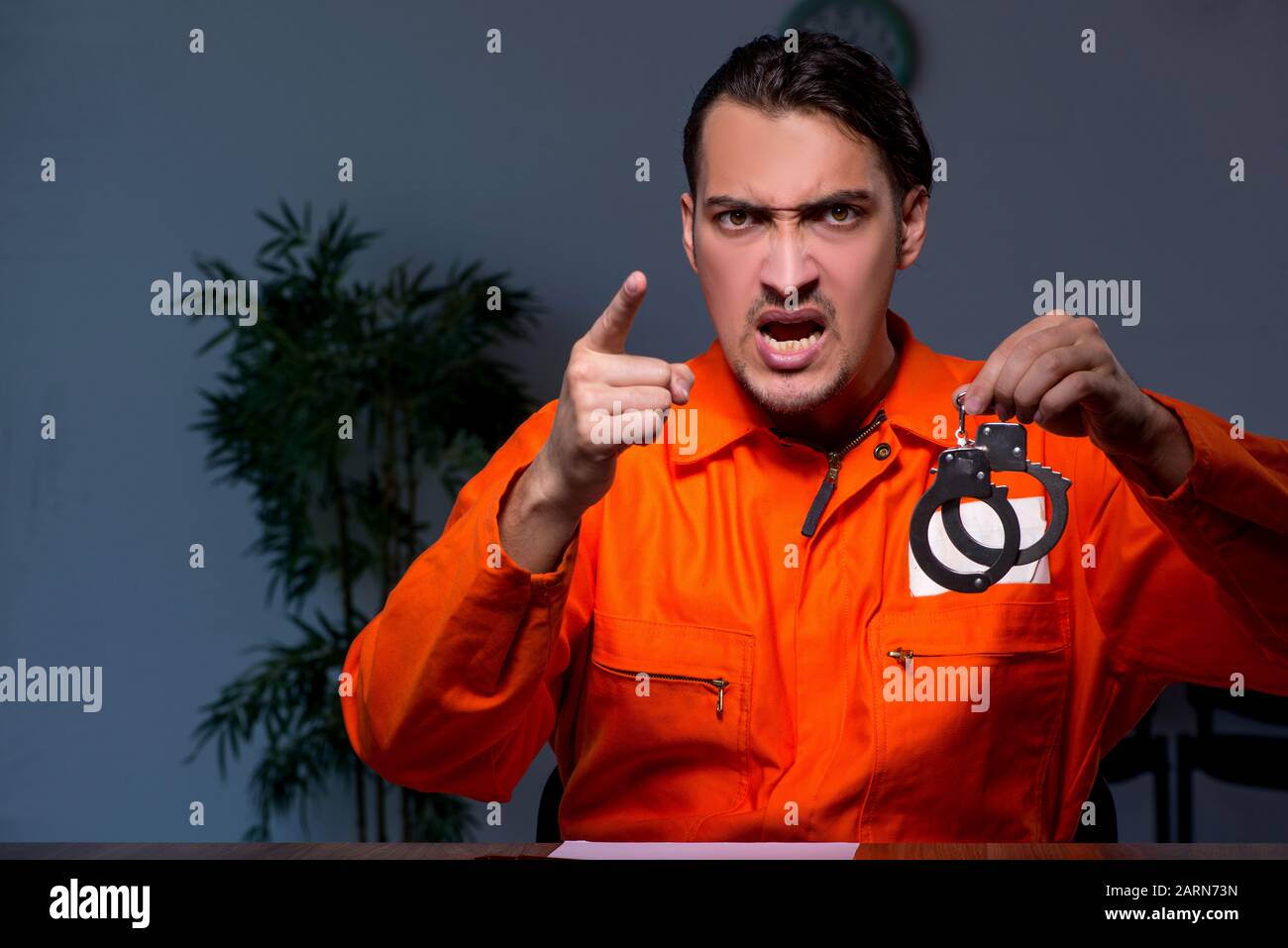 The young convict man sitting in dark room Stock Photo - Alamy