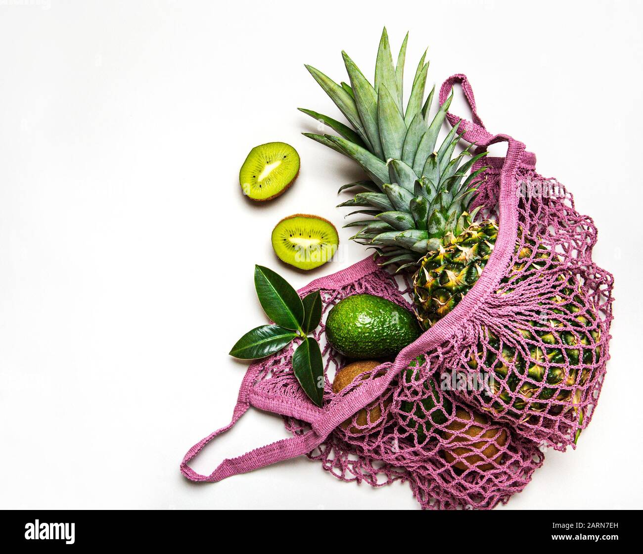 Mesh shopping bag with organic fruits on white background. Flat lay ...
