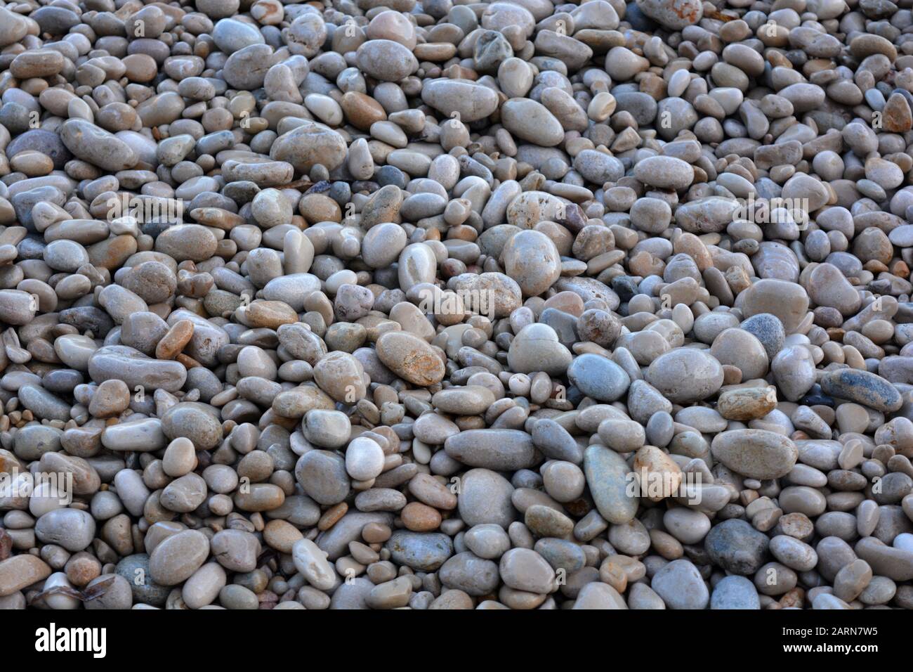 Wet, stone washed, smooth pebbles on a beach Stock Photo - Alamy