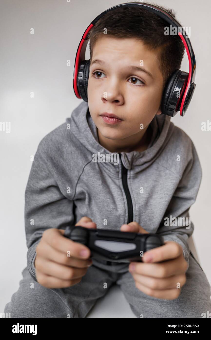 child boy playing video games over gray background. young gamer playing ...
