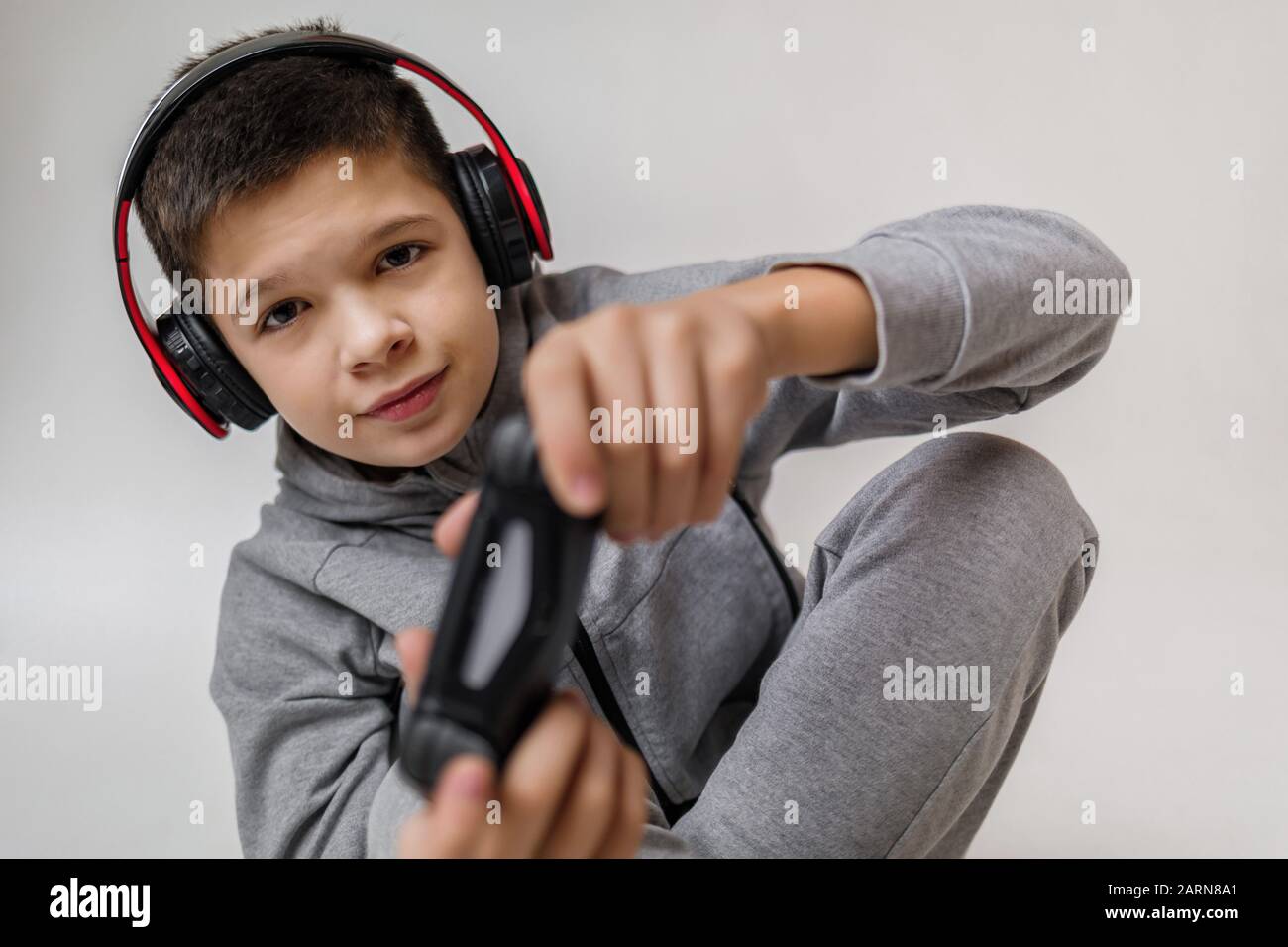 concentrated child boy playing video games over gray background. young ...