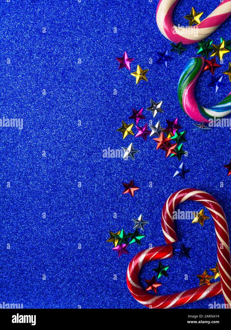 Happy holidays greeting card with striped candy canes in a heart shape ...