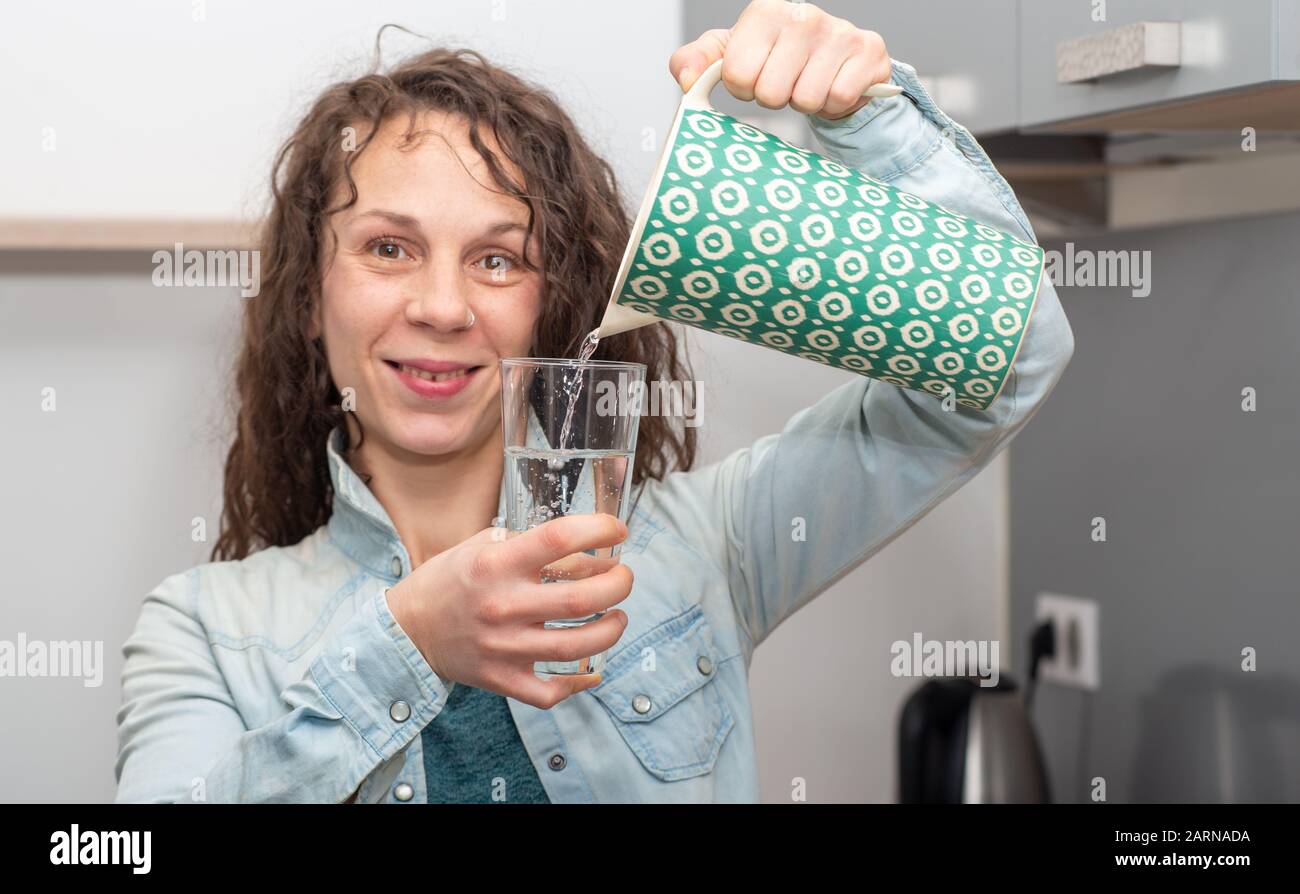 portrait of long haired beautiful woman pouring a glass of water Stock ...