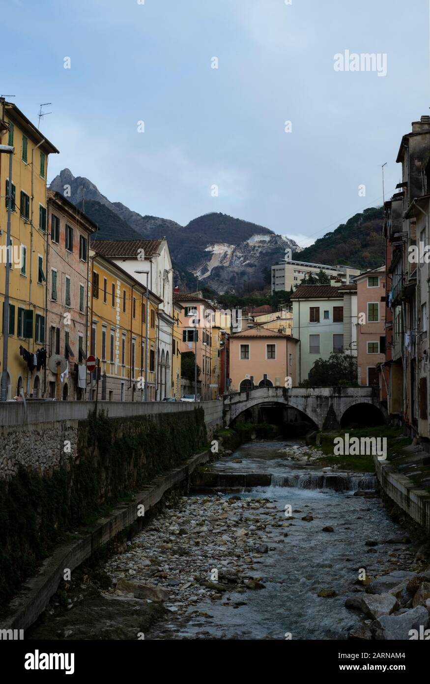 River flowing through Carrara, Tuscany, Italy under an arched bridge ...