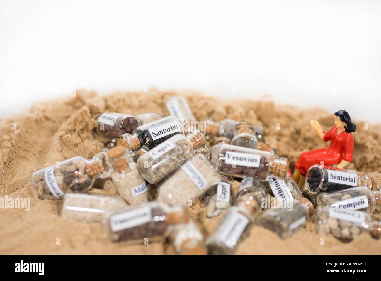Glass test-tube with sand of different summer vacation destinations ...