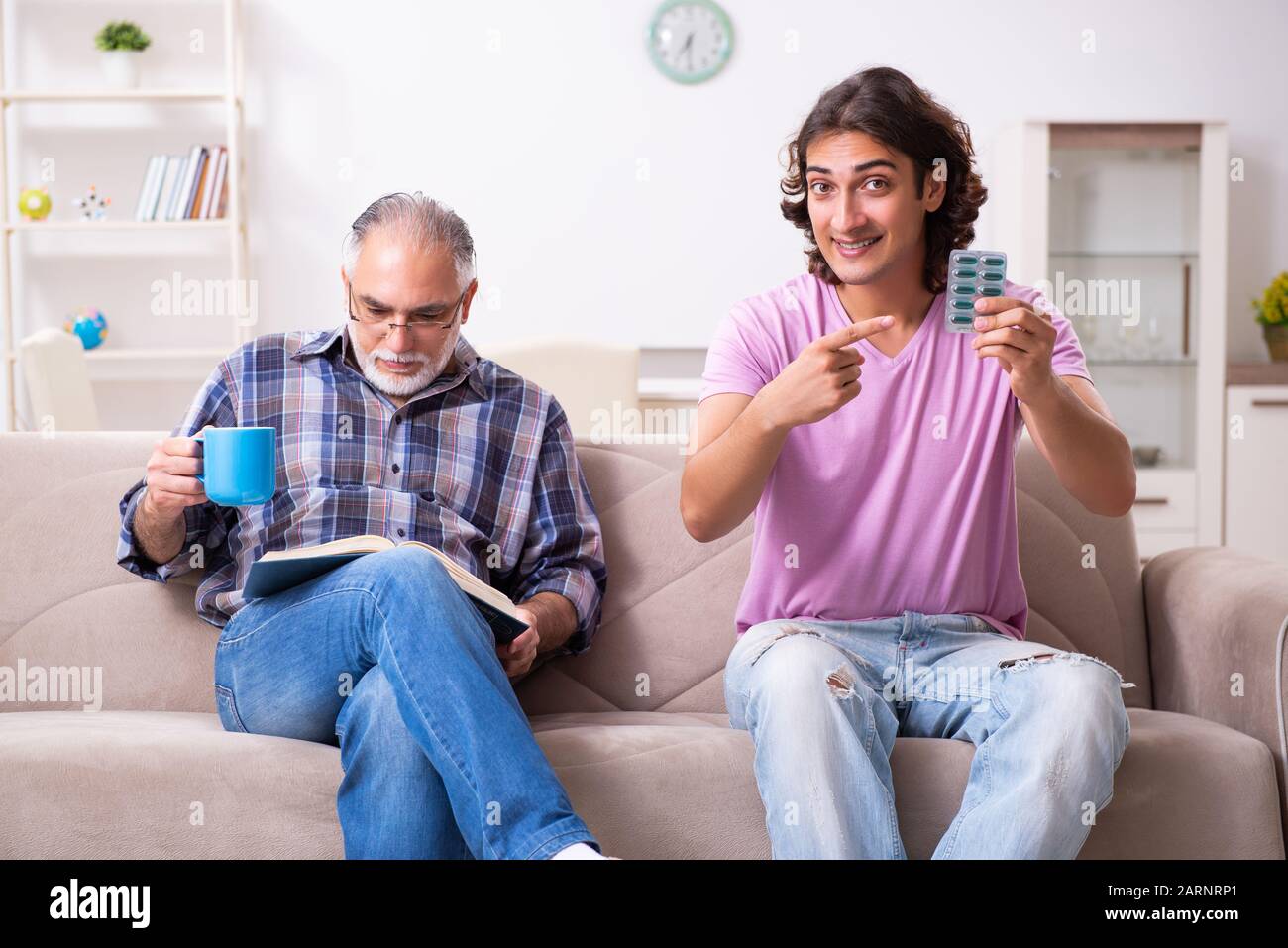 The young student and his old grandpa at home Stock Photo - Alamy