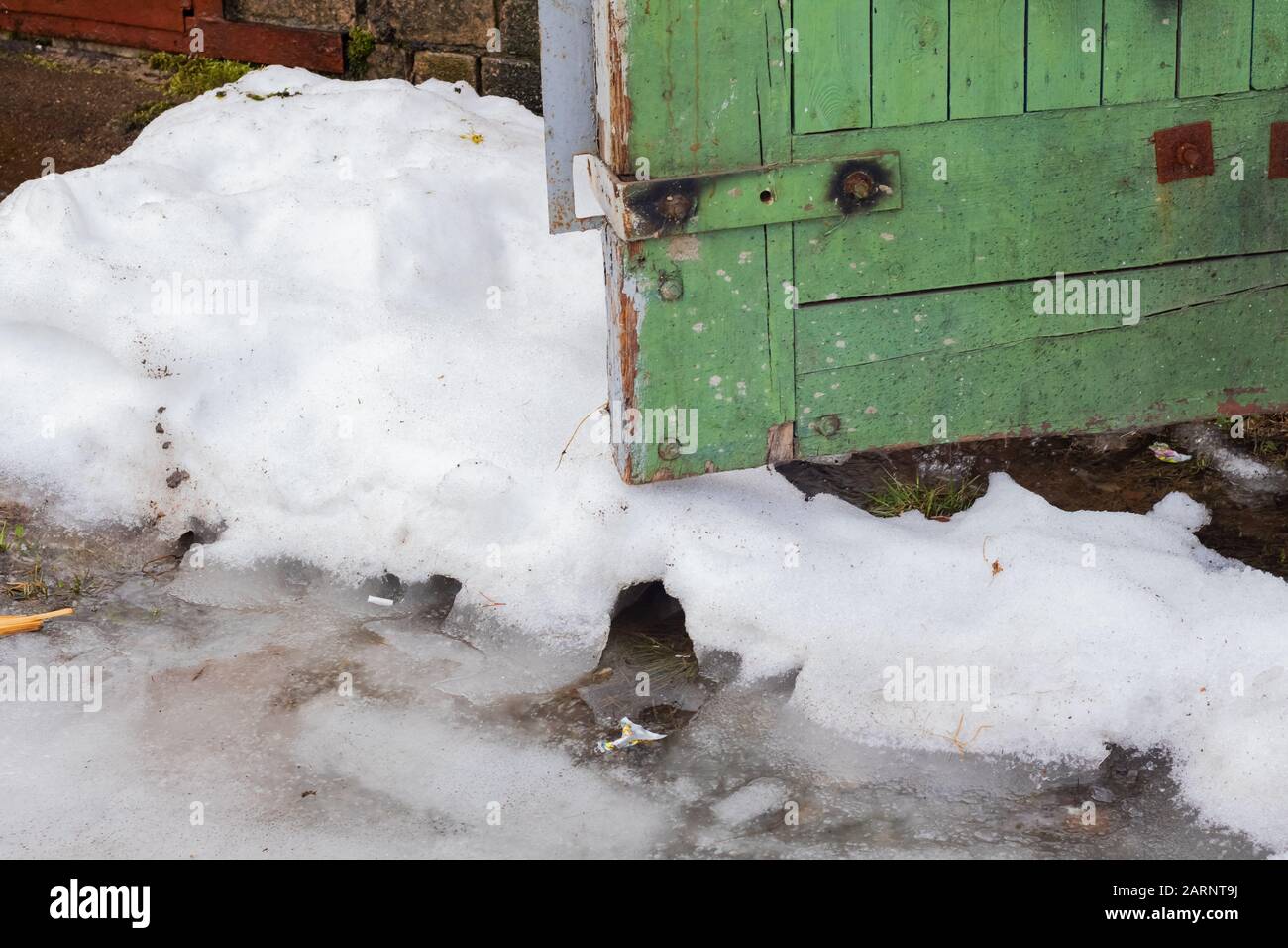 Edge of a green wooden door in a snowdrift Stock Photo - Alamy