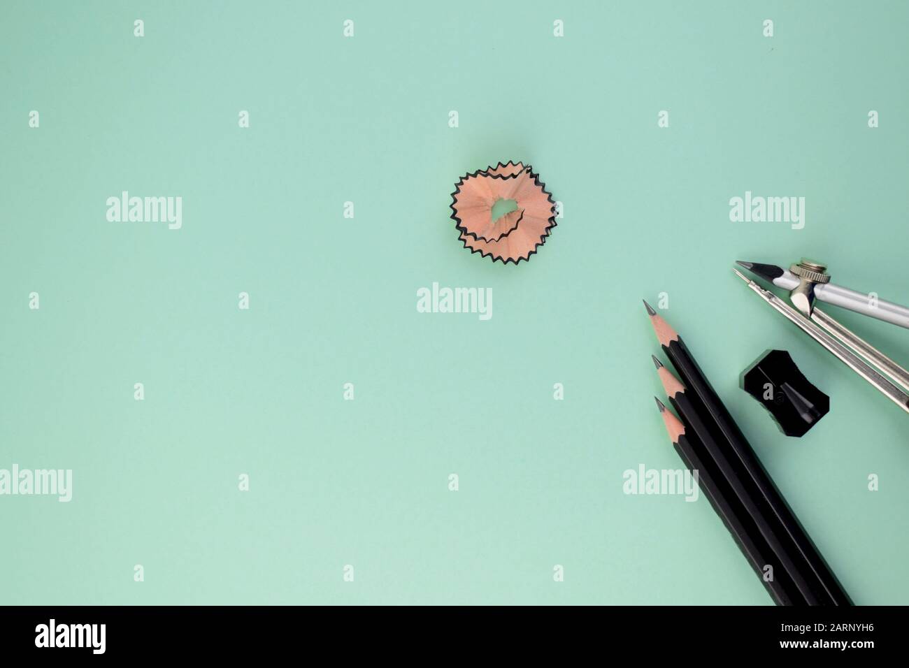 three black pencils along side a black sharpener and a pencil compass ...