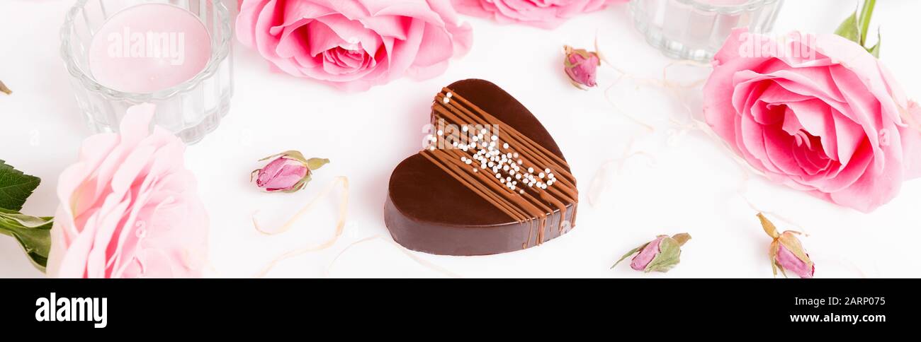 Chocolate candy heart and pink roses on white background Stock Photo ...