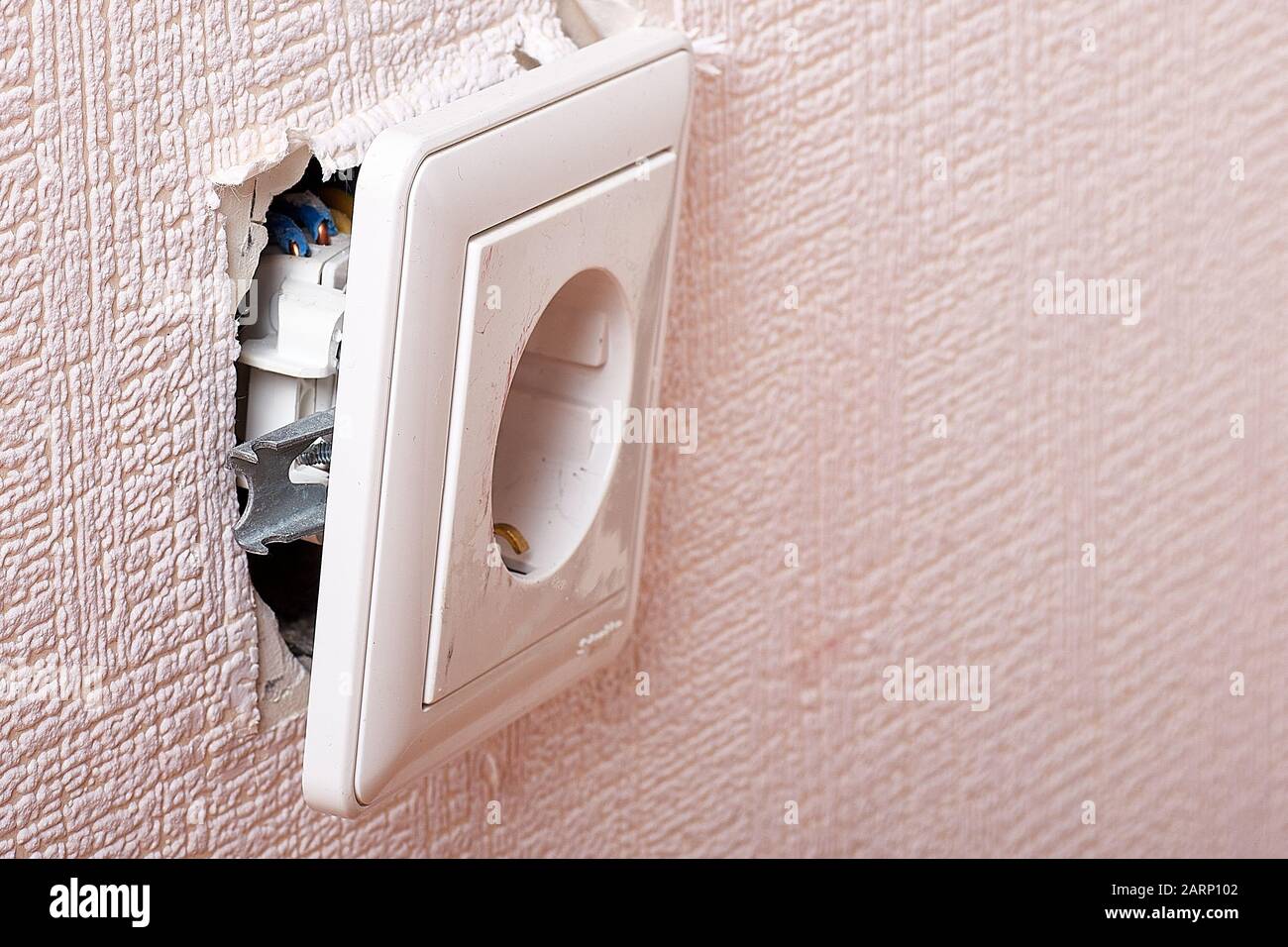 Broken electrical outlet hanging on wires from a wall Stock Photo - Alamy