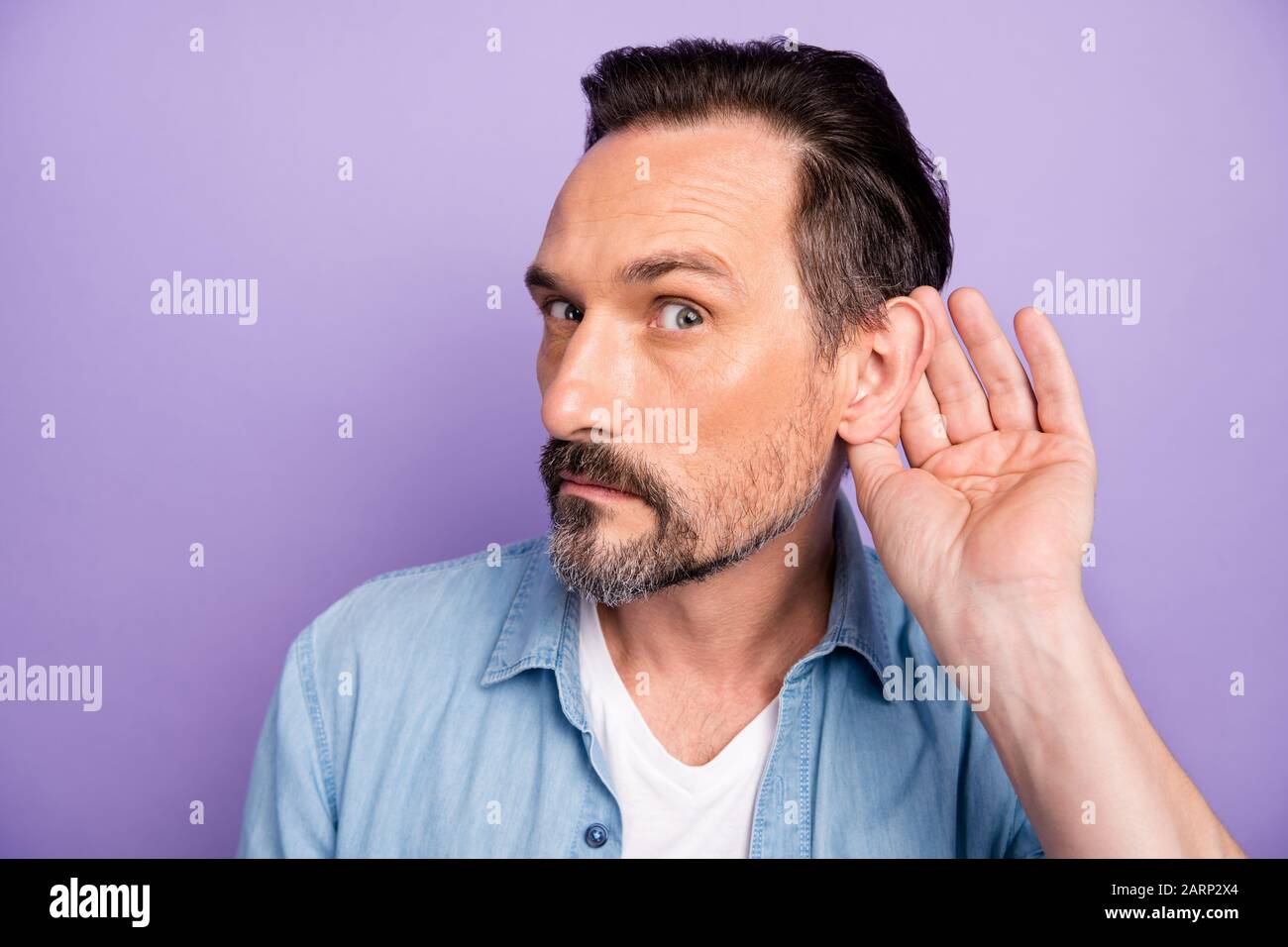 What did you say. Serious man hold hand near ears listen private ...