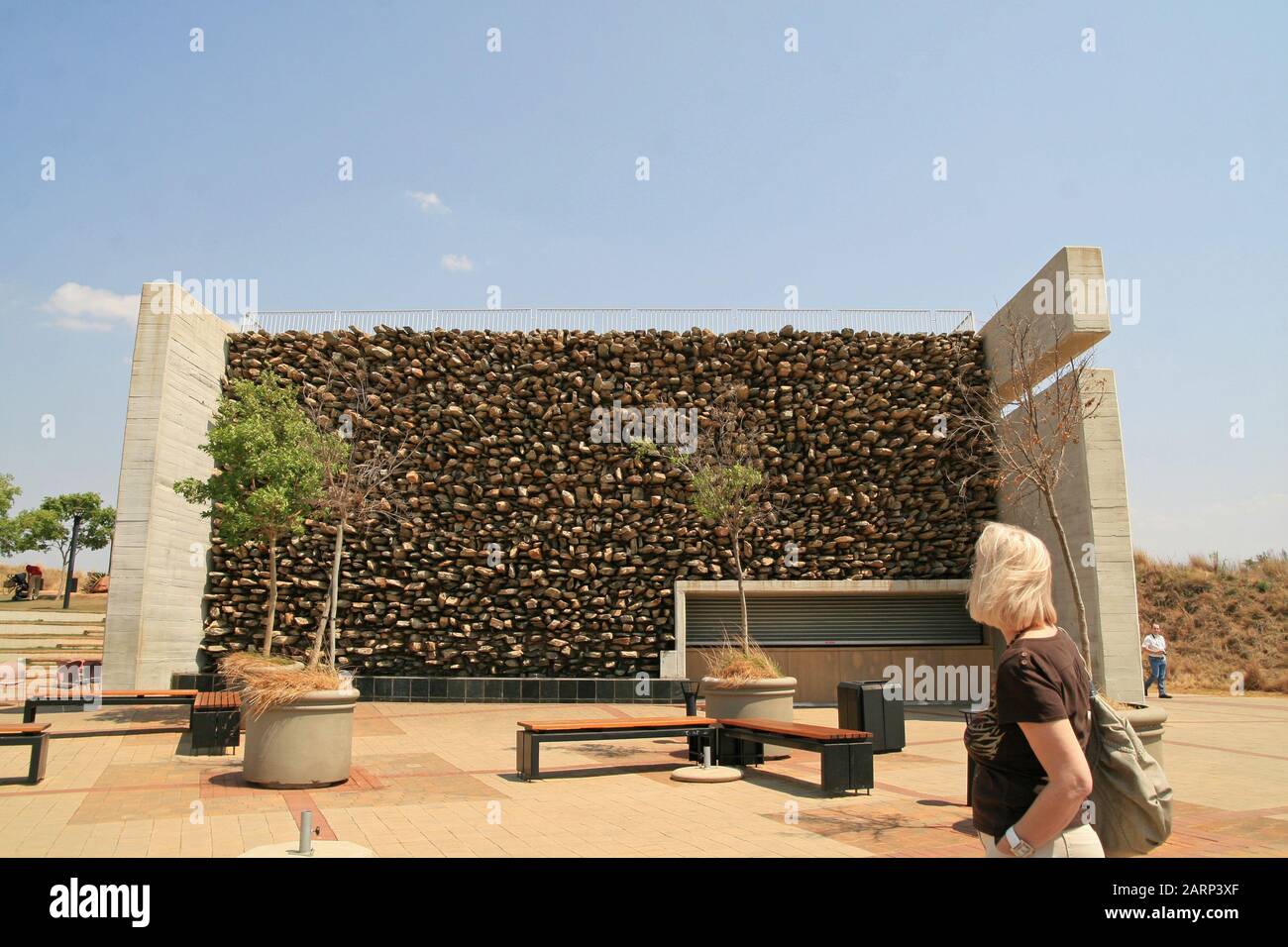 Tourist at building with rock wall, at The Cradle of Humankind ...