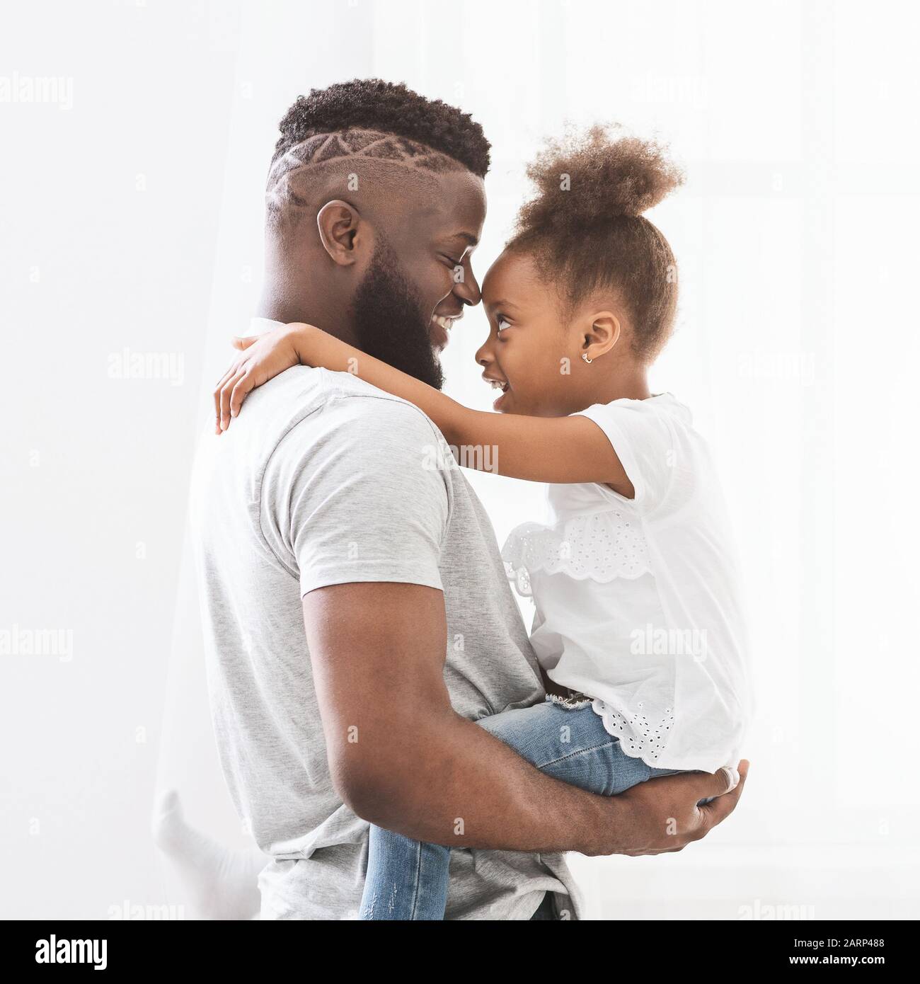 Profile portrait of black father and daughter bonding over white Stock ...
