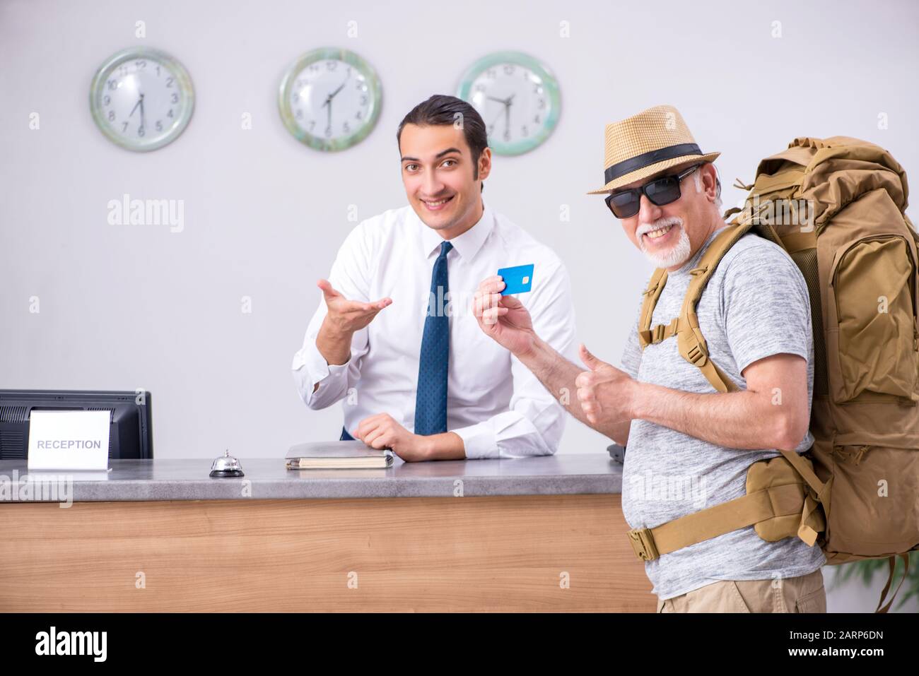 Old backpacker at the hotel reception Stock Photo - Alamy