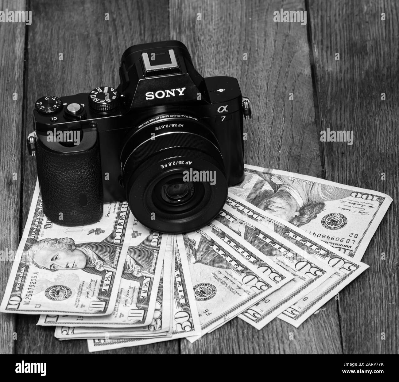 Sony a7 mirrorless camera with 35mm mounted lens, camera on dollars ...