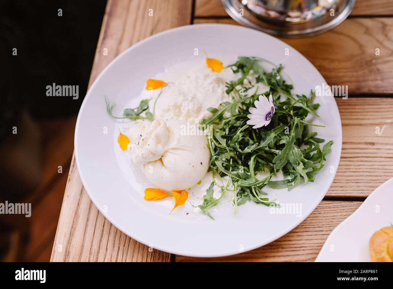 A Buratto ball and arugula raab salad on a plate. A delicious ball of ...