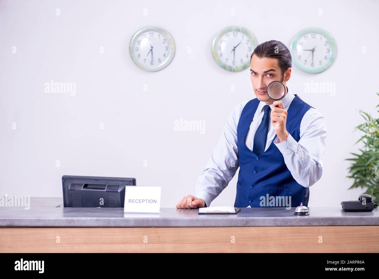 The young man receptionist at the hotel counter Stock Photo - Alamy