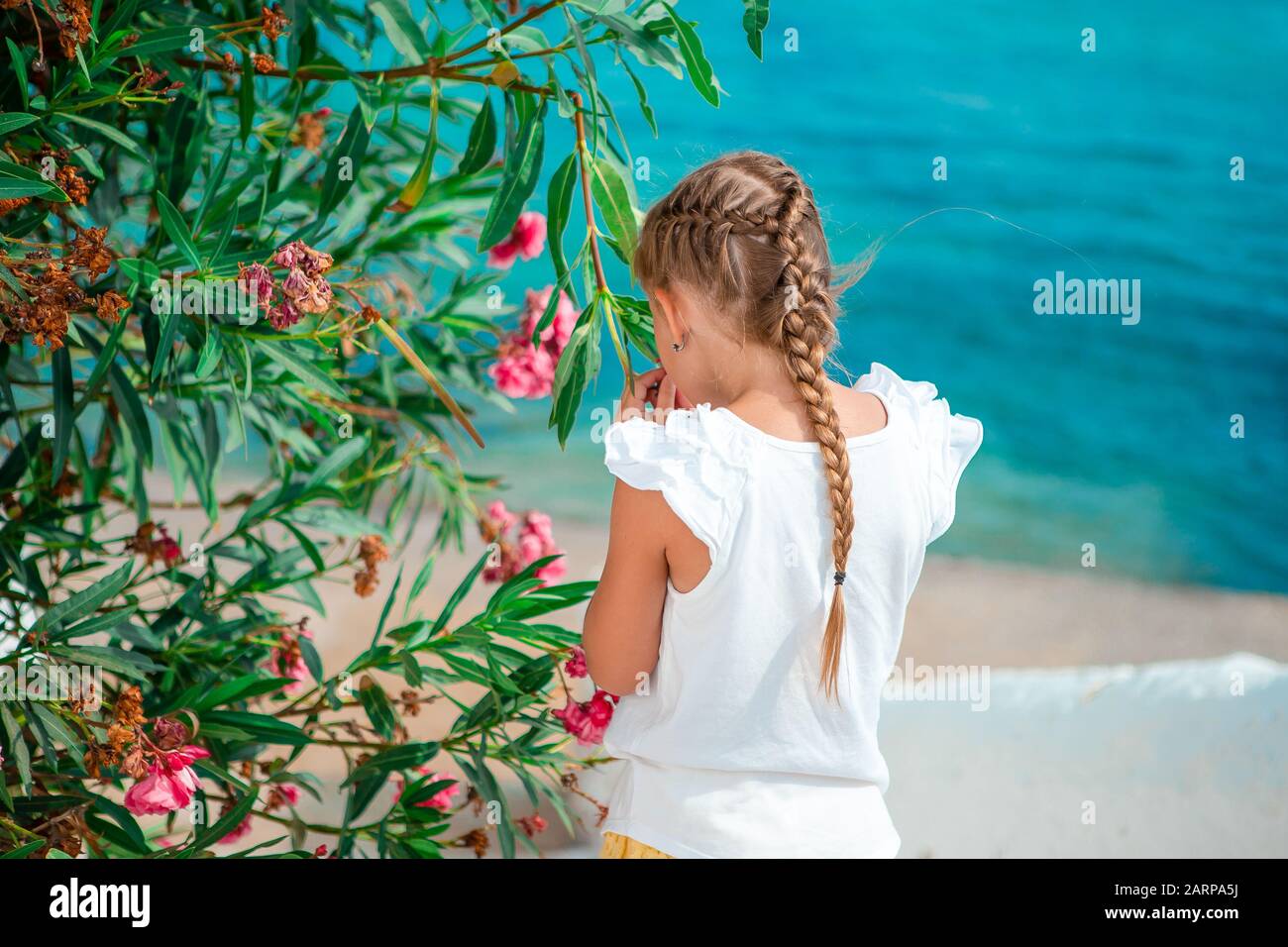 Adorable little girl at old street of typical greek traditional village ...