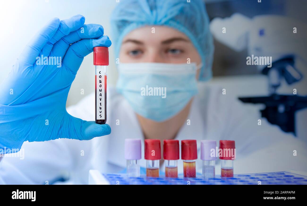 Scientist wearing respirator mask holding positive blood test Stock ...