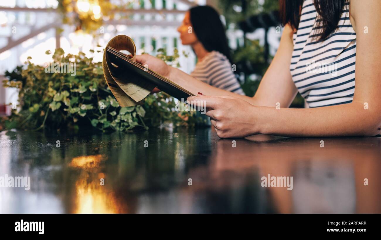 The girl choosing the menu at the bar Stock Photo - Alamy
