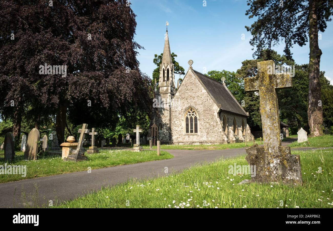 A quiet view of a typical old English graveyard with a small chapel of ...