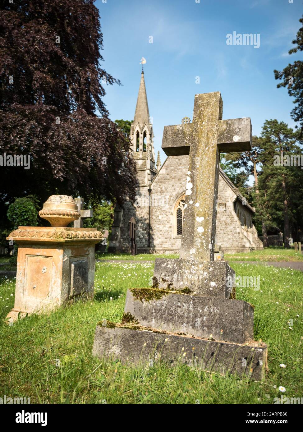 Traditional old English grave yard scene with a crucifix headstone in ...