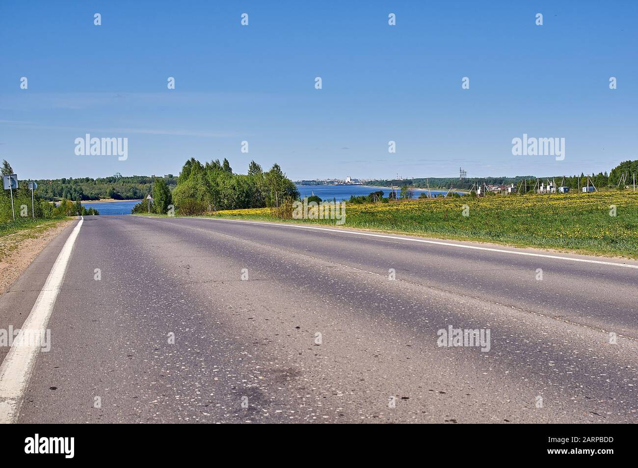 Summer landscape. Asphalt road leading to the river through green ...