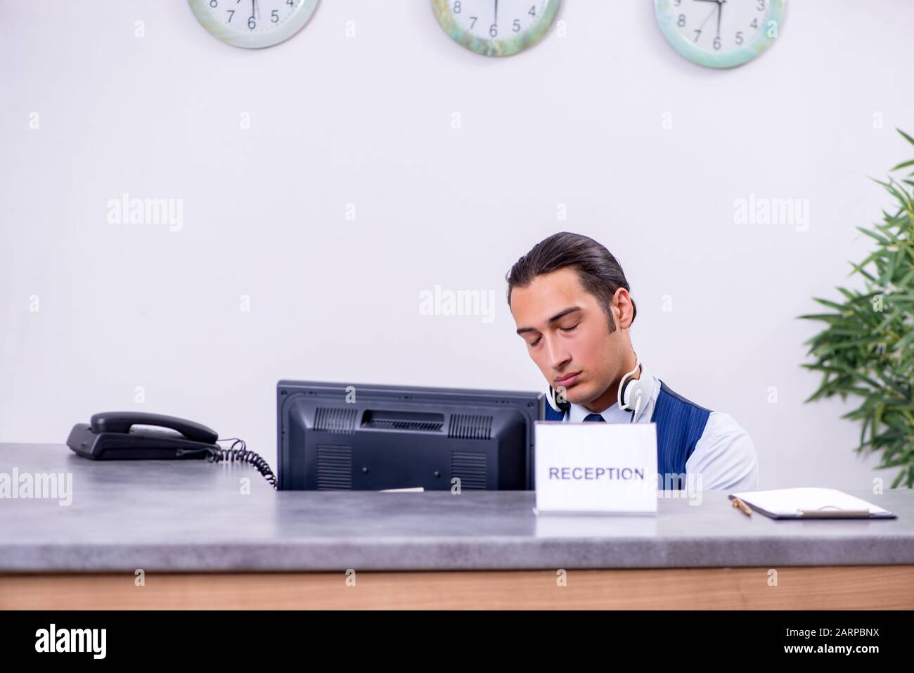 The young man receptionist at the hotel counter Stock Photo - Alamy