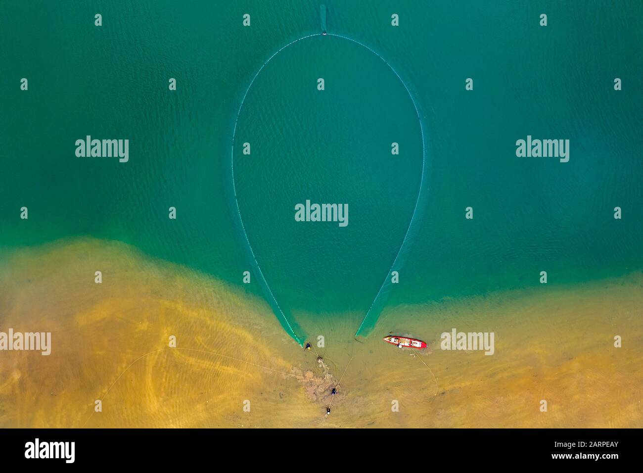 Fishermen pull a net into a circle to catch fish Stock Photo - Alamy
