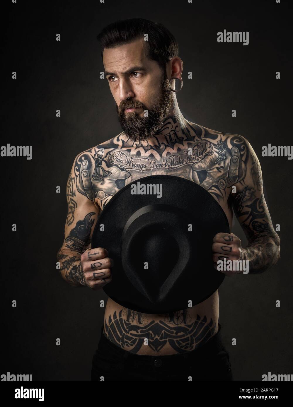 Studio Portrait of a male model with beard and tattoos Stock Photo - Alamy