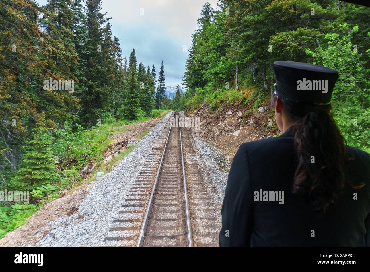 Lady conductor is looking from the train. Skagway, Alaska, worker on ...