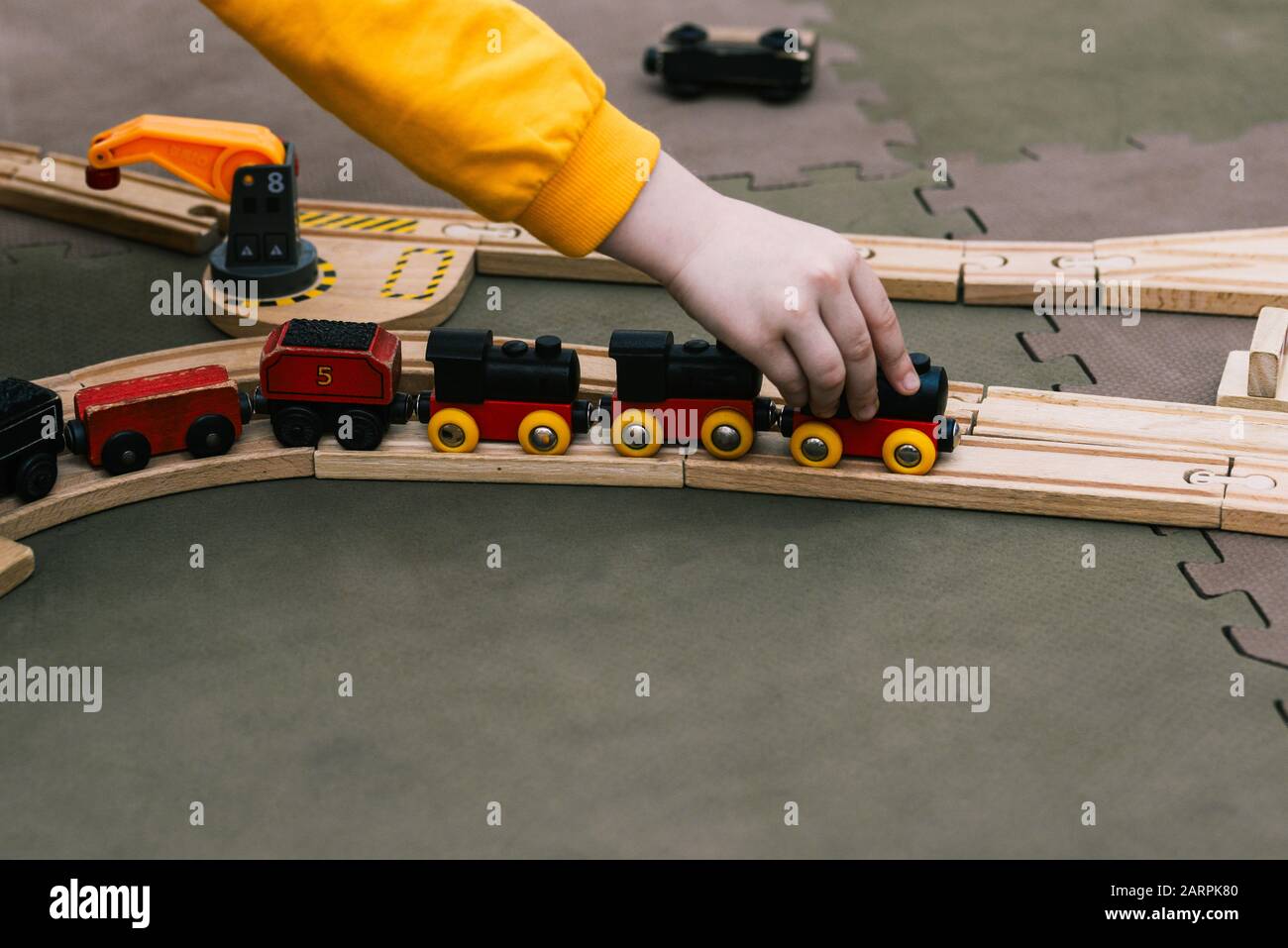 Toy railway. Children's hand drives a toy wooden train. An exciting ...