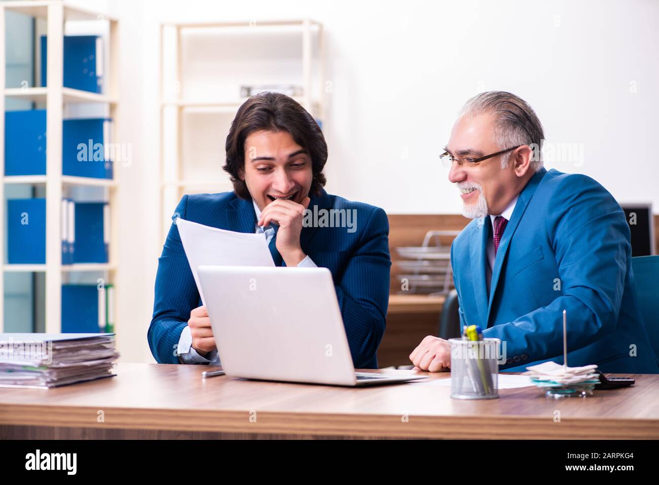 The young and old employees working together in the office Stock Photo ...