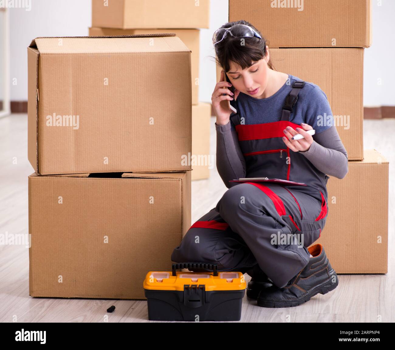 The woman contractor moving boxes in relocation concept Stock Photo - Alamy