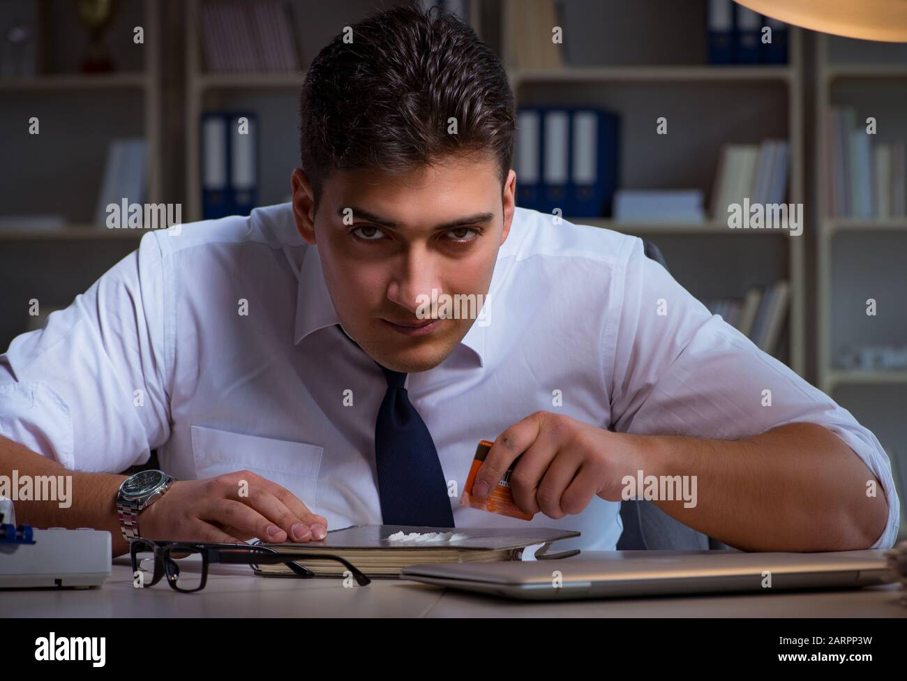 The businessman staying late in office for drugs Stock Photo - Alamy