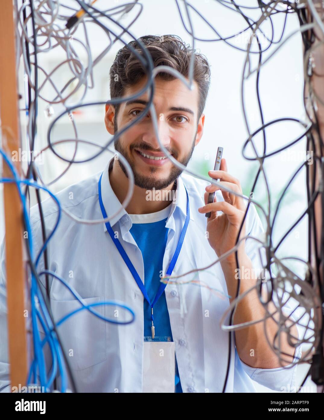 The electrician trying to untangle wires in repair concept Stock Photo ...