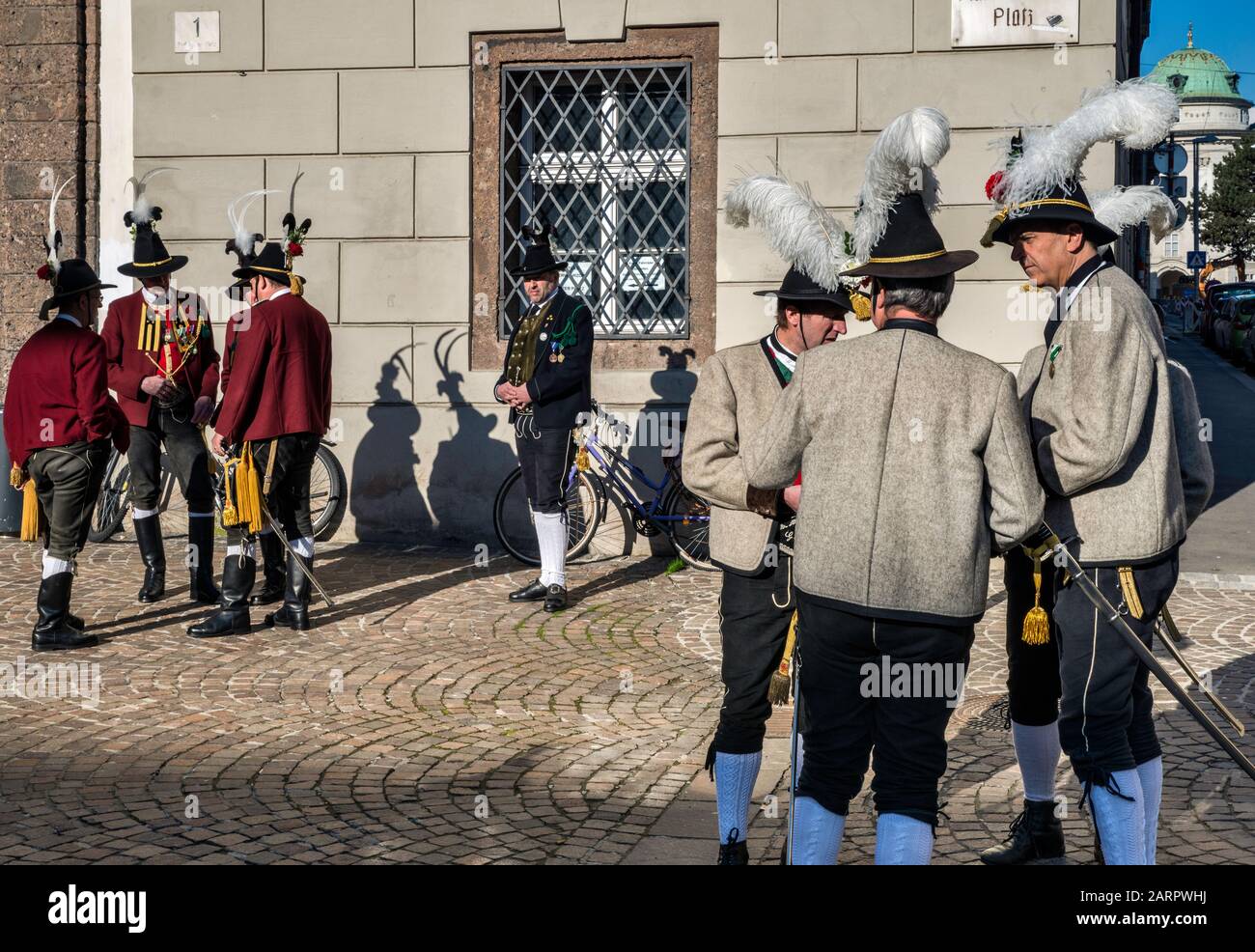 Men wearing traditional Tyrolean clothes, in front of Jesuit Church ...