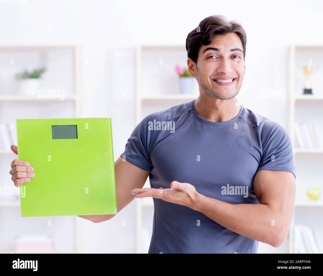 The man with scales in sports and health concept Stock Photo - Alamy