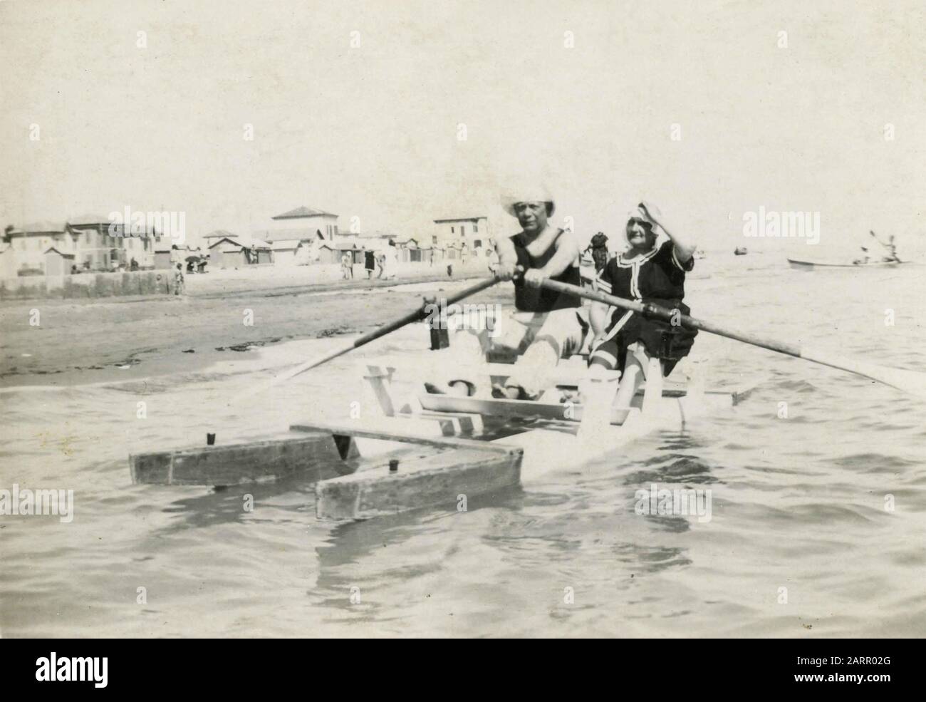 Couple rowing on a pattino beach catamaran, Italy 1910s Stock Photo - Alamy
