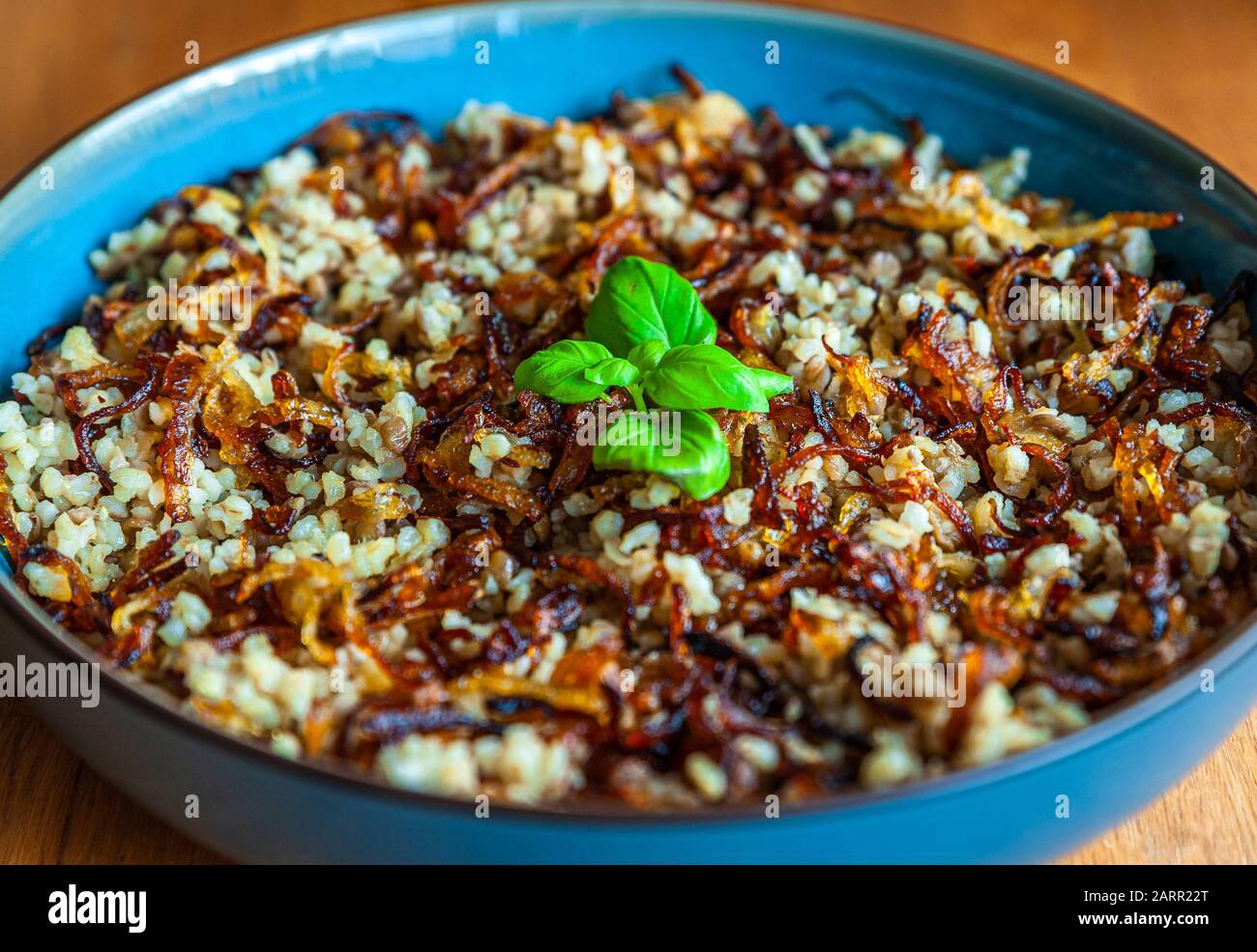Bulgur pilaf in a rustic bowl and topped with caramelized onion Stock ...