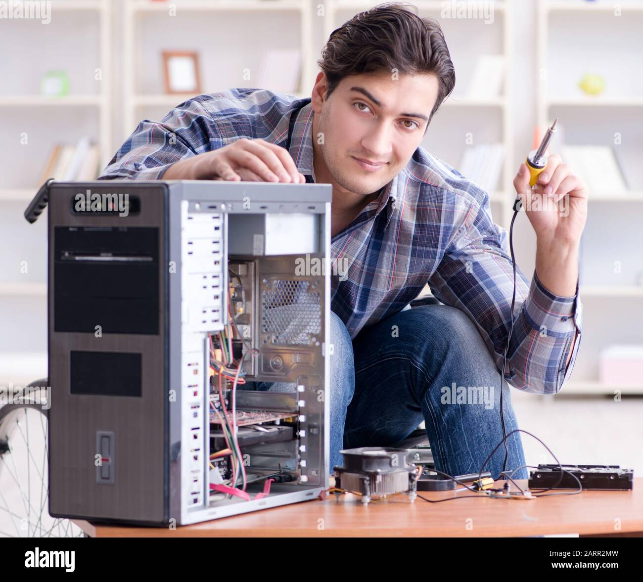 The disabled man on wheelchair repairing computer Stock Photo - Alamy