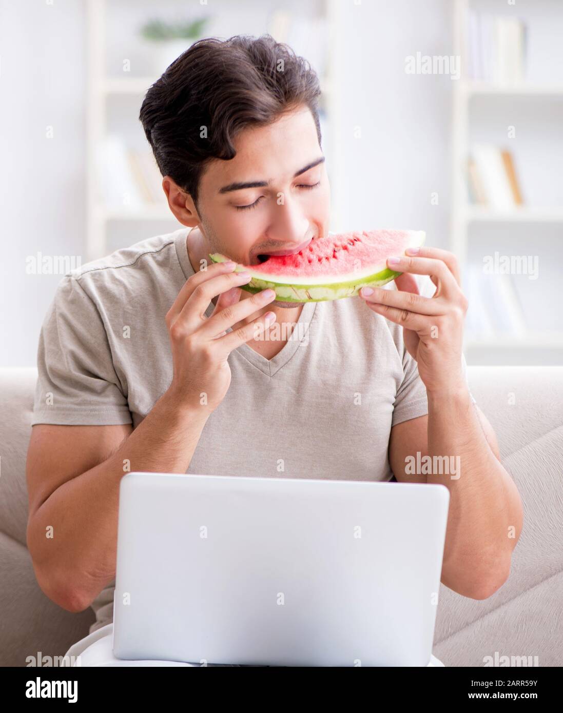 The man eating watermelon at home Stock Photo - Alamy