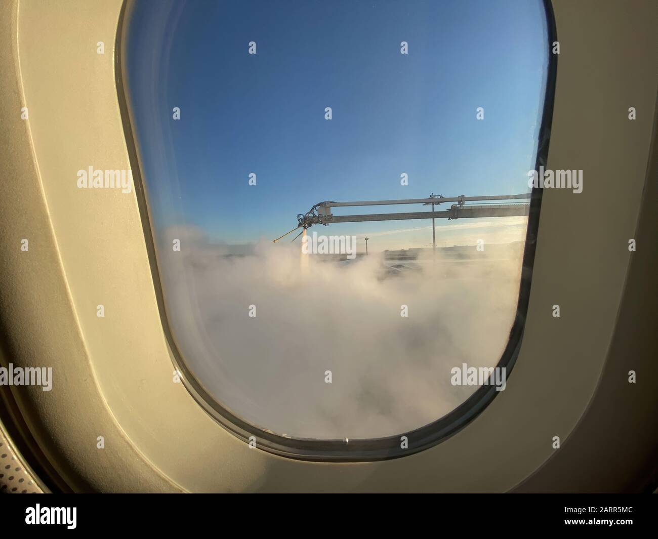 View out of airplane window deicing wing Stock Photo - Alamy