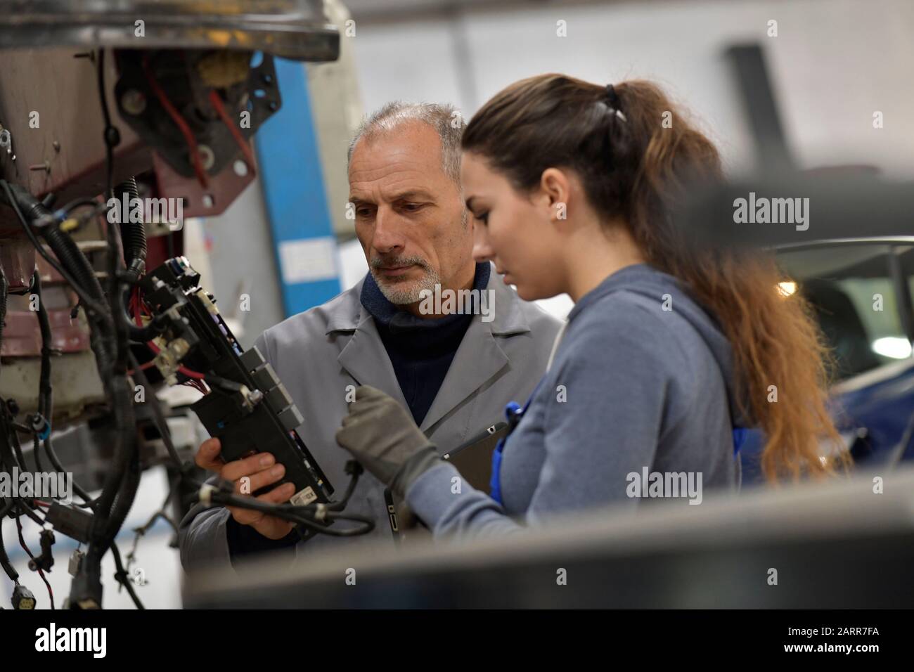 Apprentice with instructor working on vehicle Stock Photo - Alamy