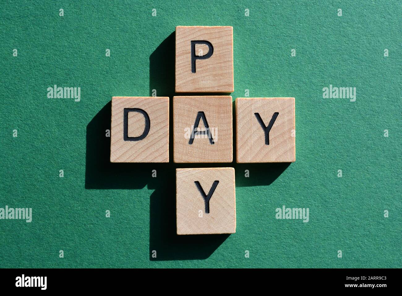 Pay Day in wooden alphabet letters in cross form on a green background ...