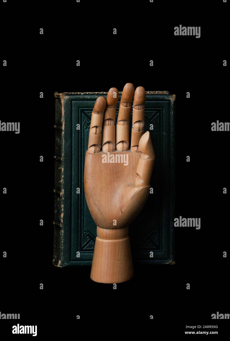 Wooden hand in front of old green leather bound book Stock Photo - Alamy