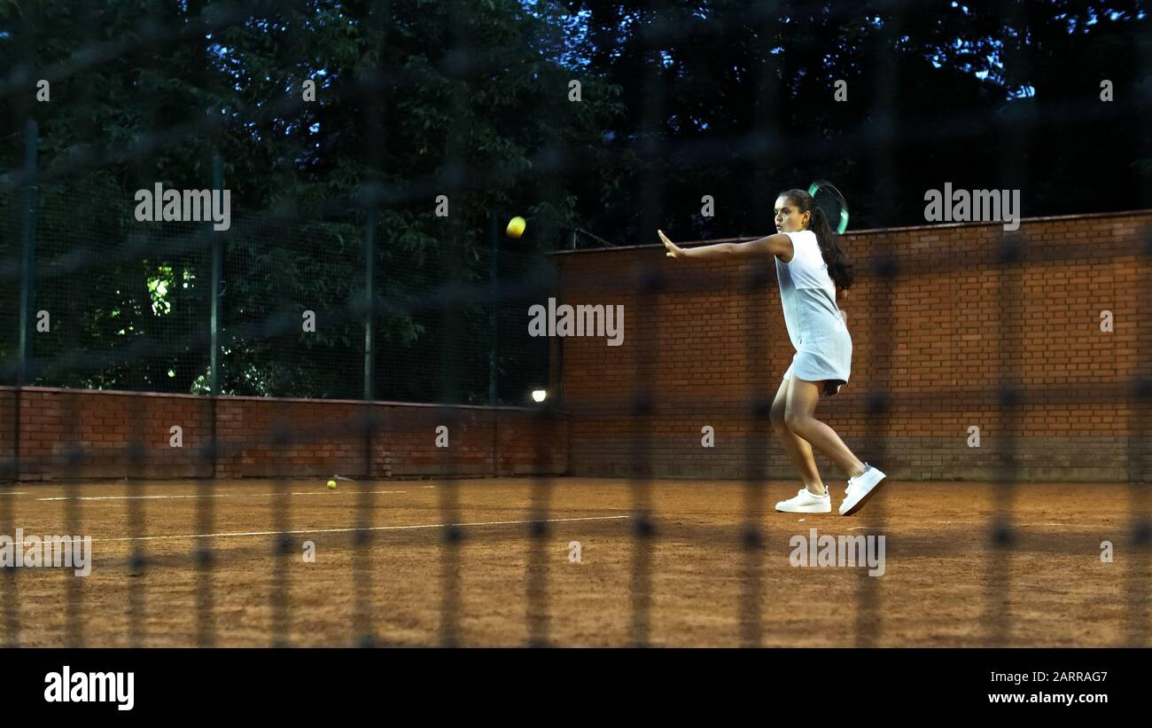 Young girl blocking the ball with the tennis racket during the training ...
